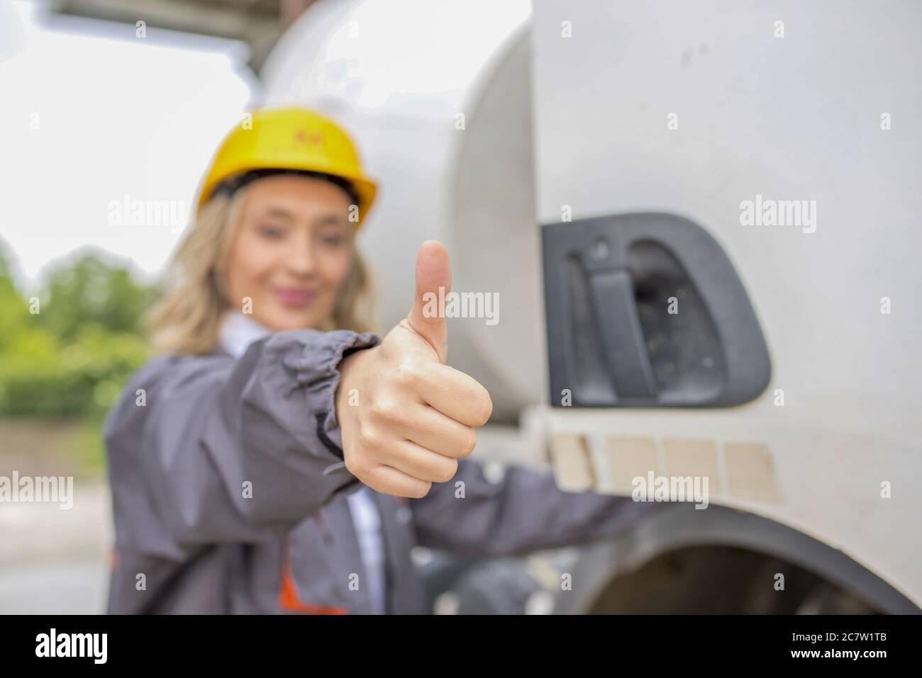 Closeup of a happy female construction worker doing the thumbs-up ...