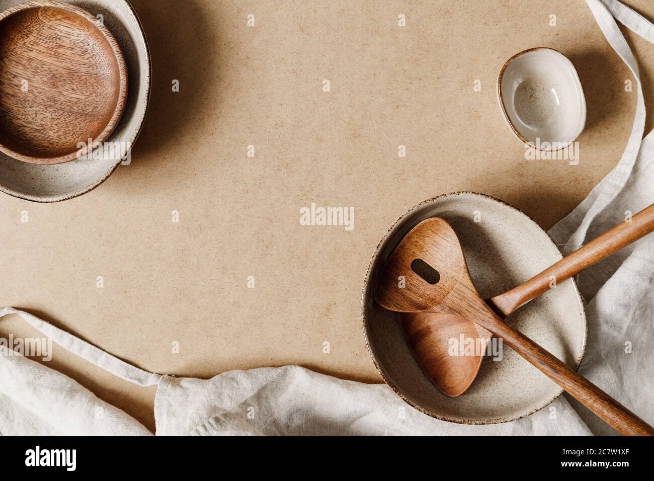 Modern minimalist ceramics set with a linen cloth over kraft paper background. Natural products ...