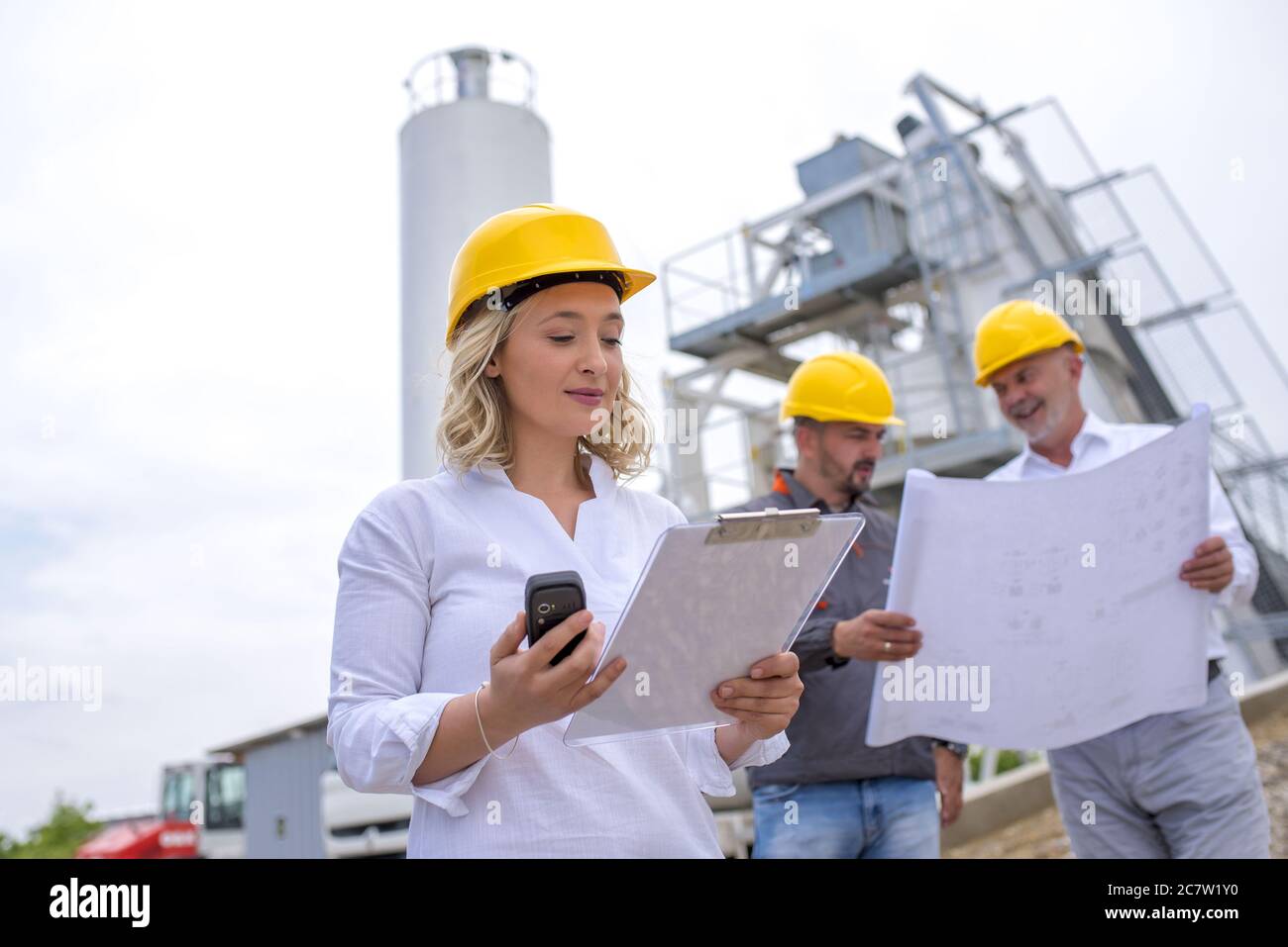 Group of construction workers looking at the plans and documents under ...