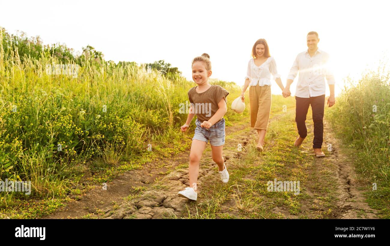 Happy parents and kid walking together outdoor in summer Stock Photo ...