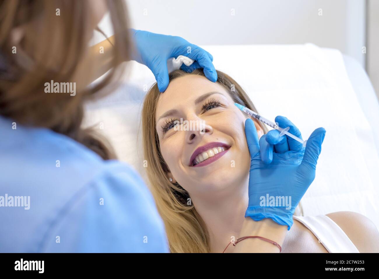 Closeup of a doctor performing cosmetic surgery on a young female under ...
