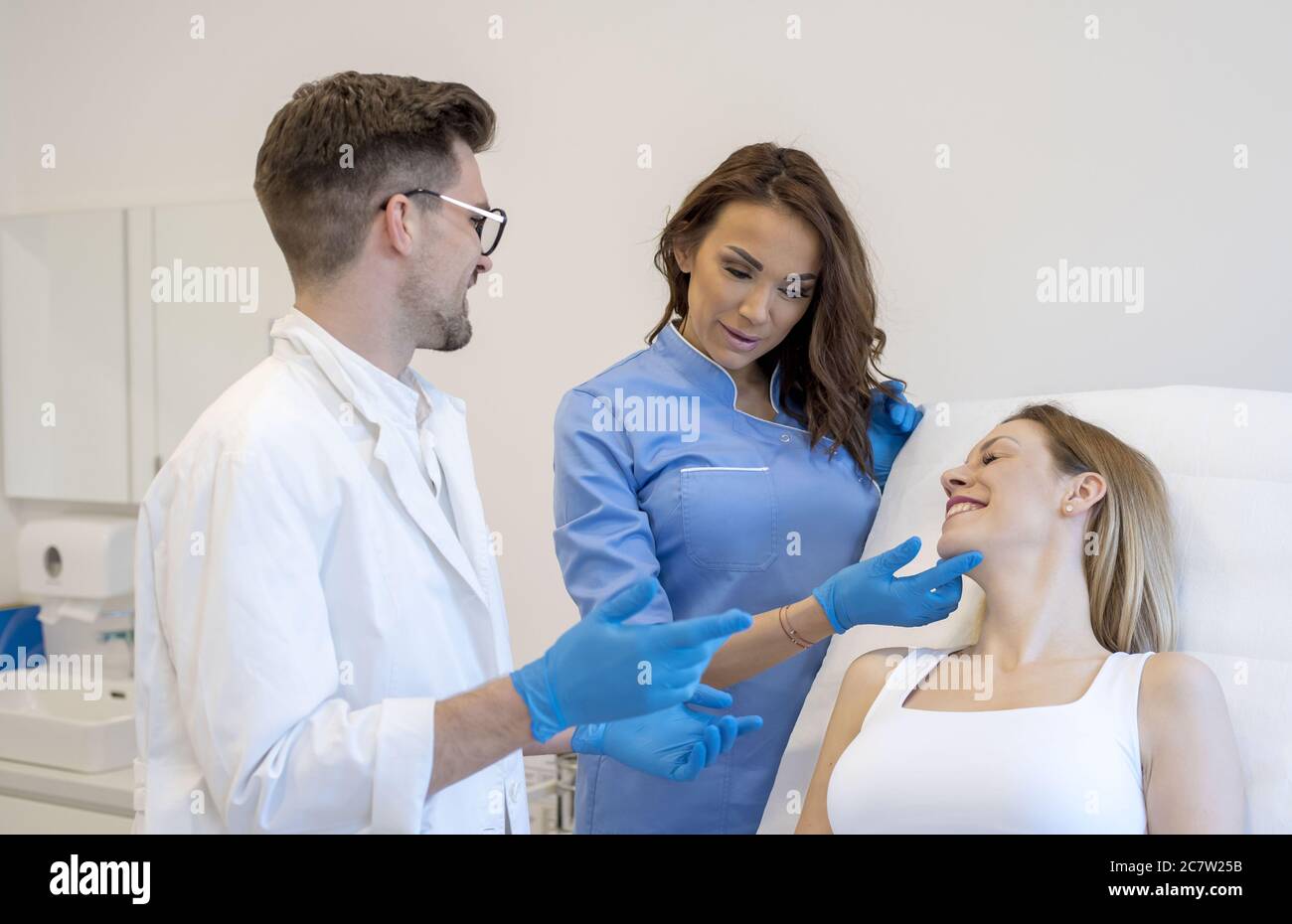 Doctors checking the face of a young female before performing cosmetic ...