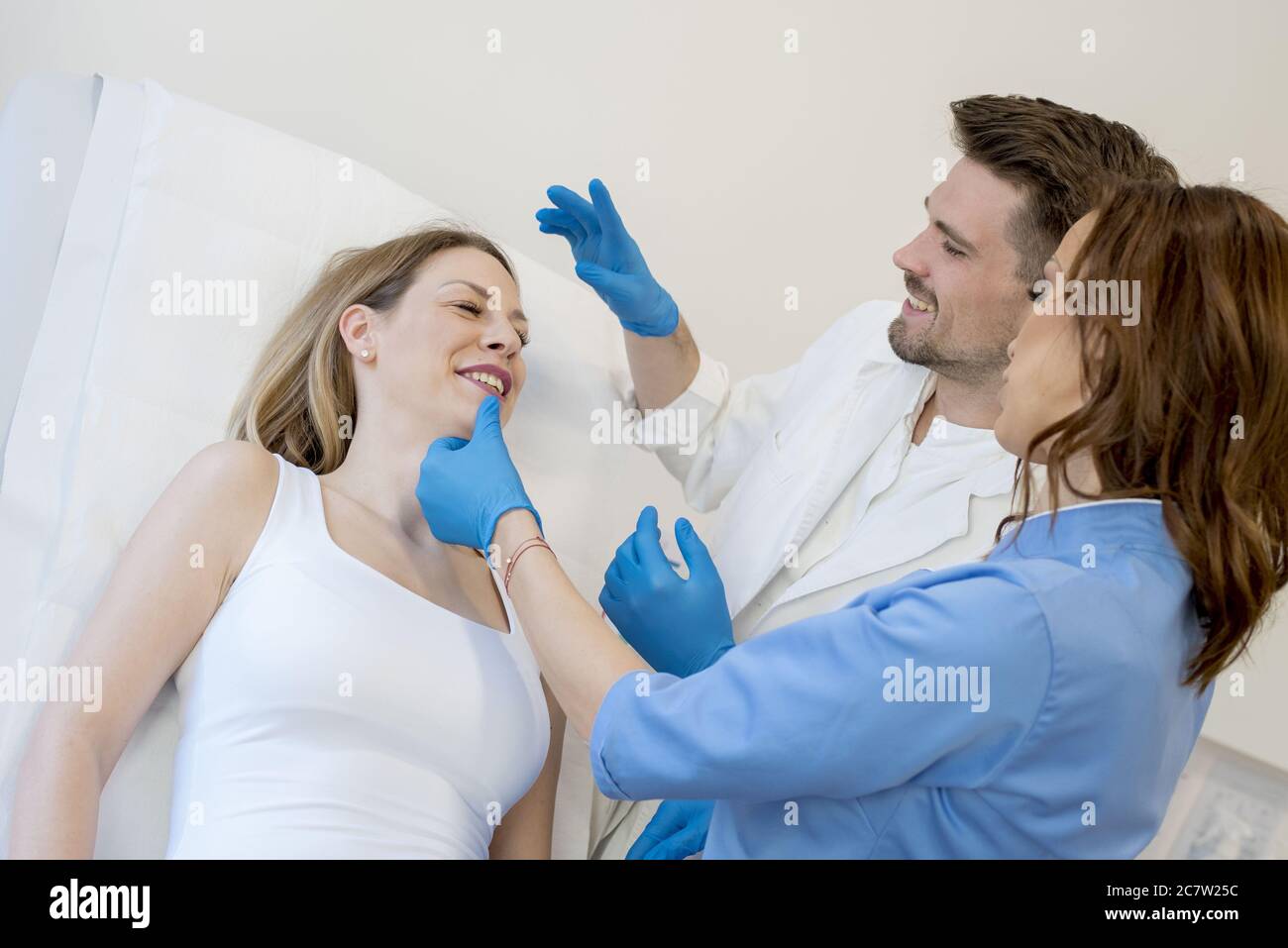 Doctors checking the face of a young female before performing cosmetic ...