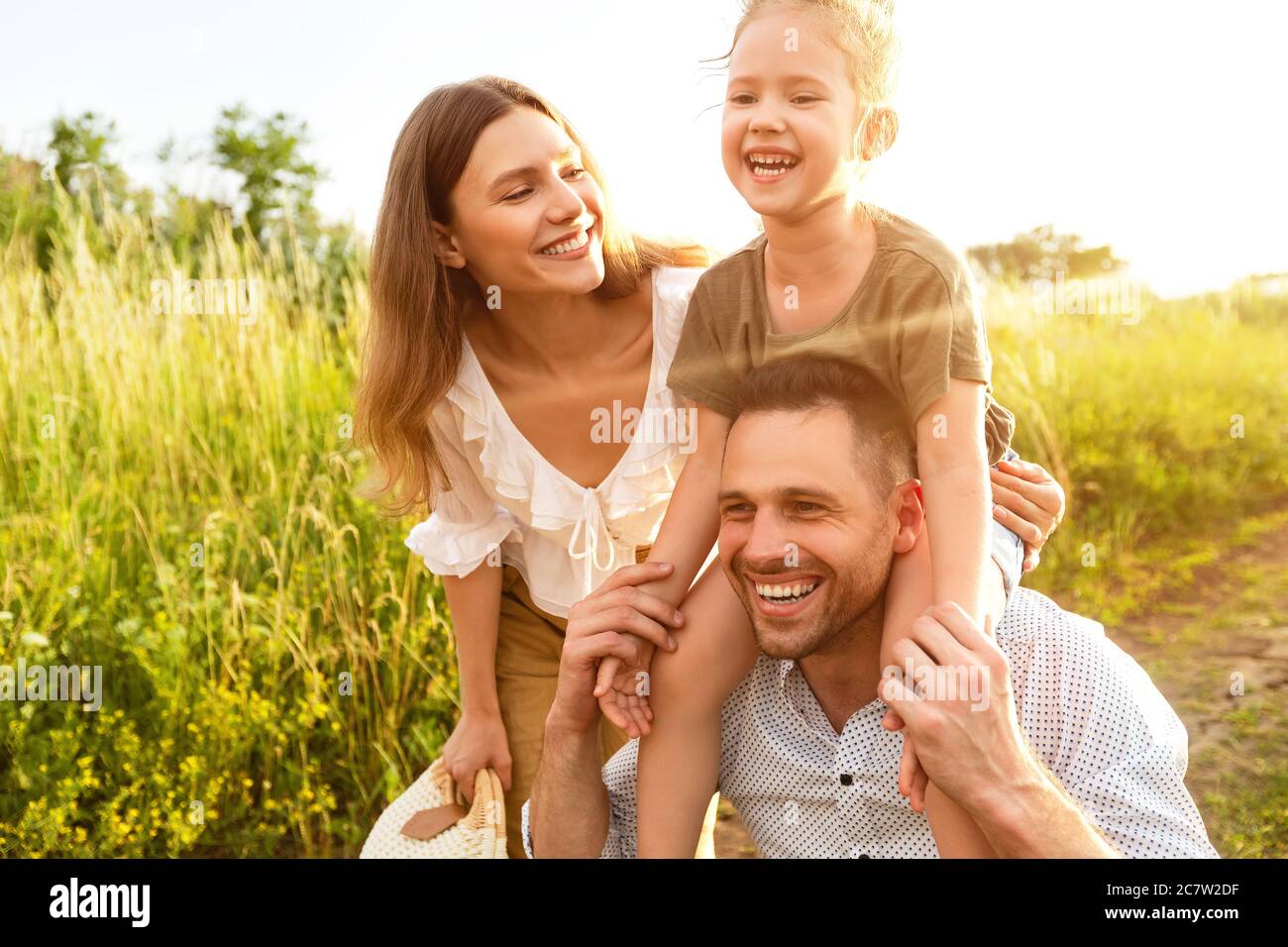 Daughter smiling and sitting on the neck of her father Stock Photo - Alamy