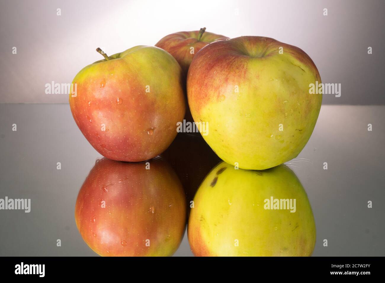 Three red apple on mirroring table. Gorizontal image with copy space ...
