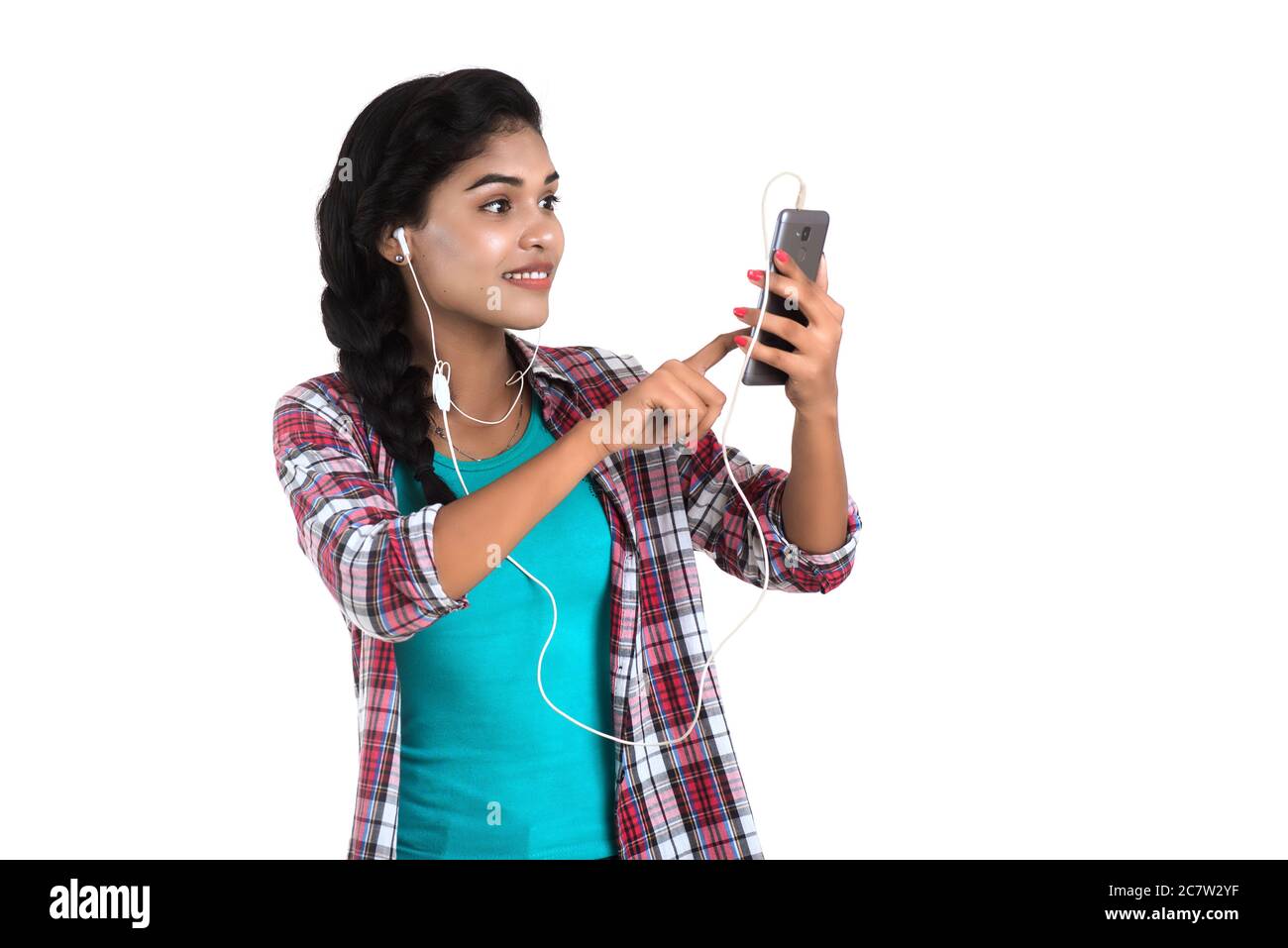 Young Indian girl using a mobile phone or smartphone isolated on a ...