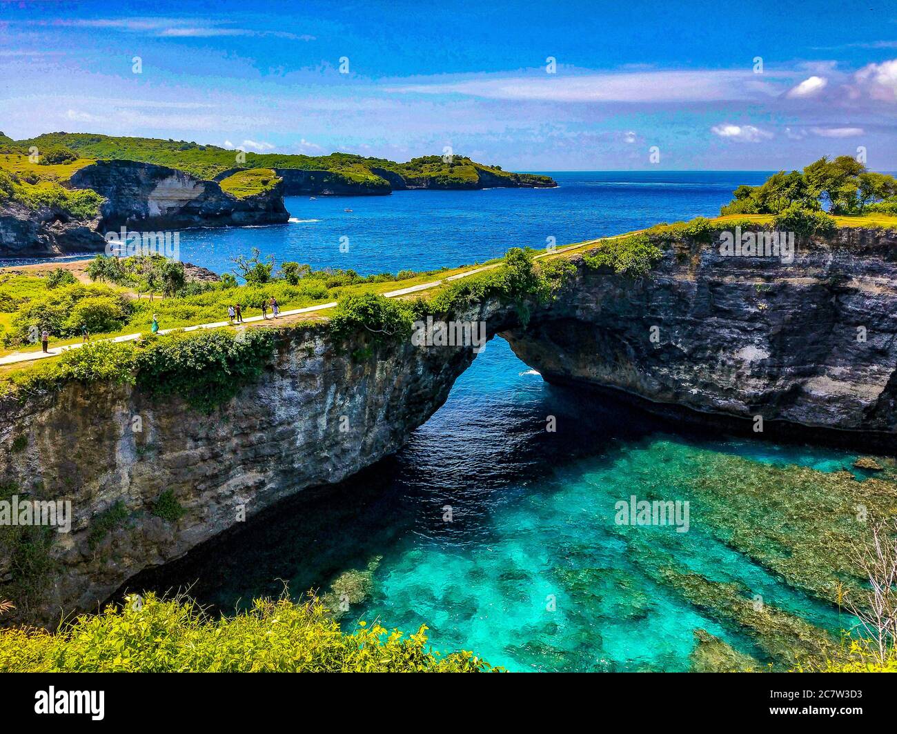 Rock coastline. Stone arch over the sea. Broken beach, Nusa Penida ...