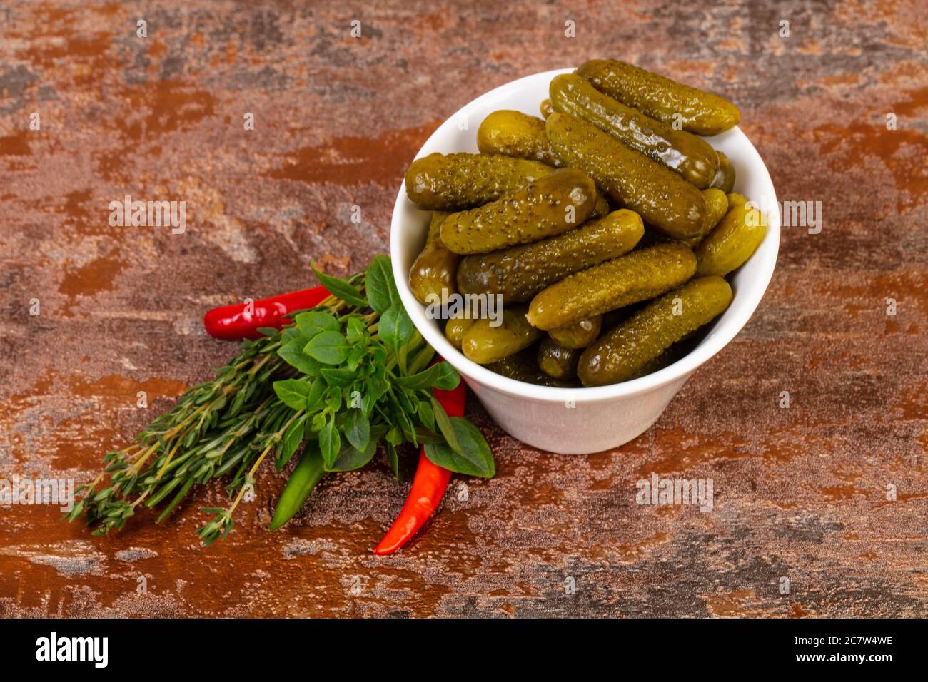 Pickled small cucumbers in the bowl served herbs Stock Photo - Alamy