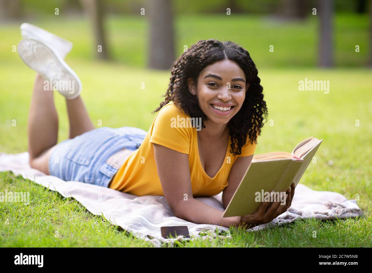 Girl Laying In Grass Reading