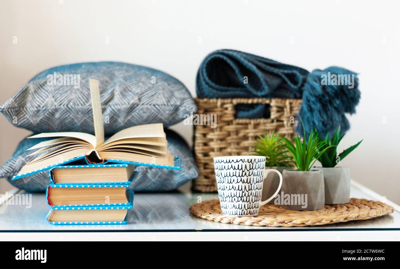 Cozy home interior decor: stack of books, plants in pots on a wicker ...