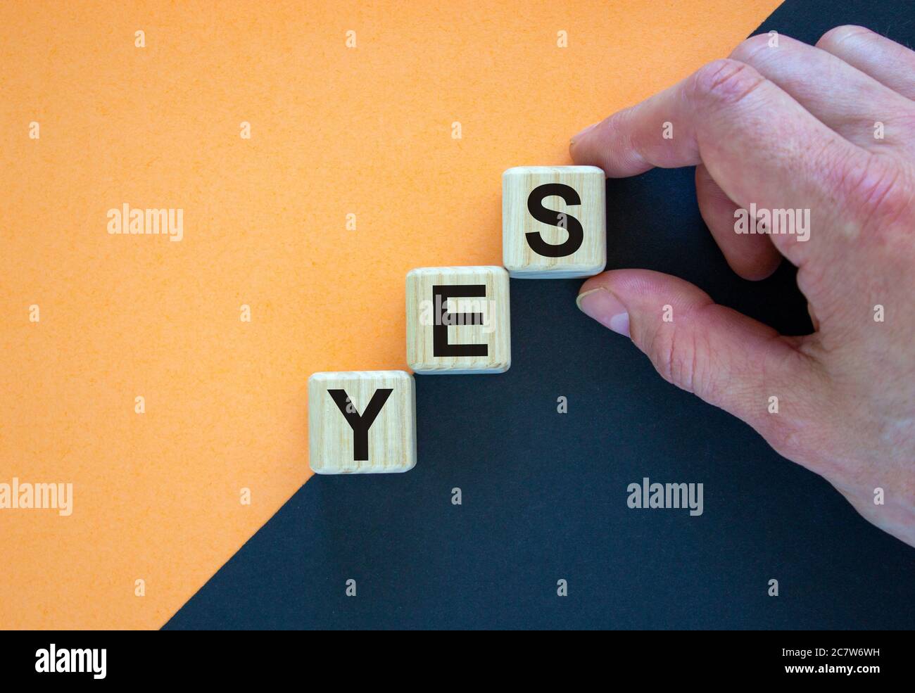 Wood block with word 'yes' stacking as step stair on paper peach and ...