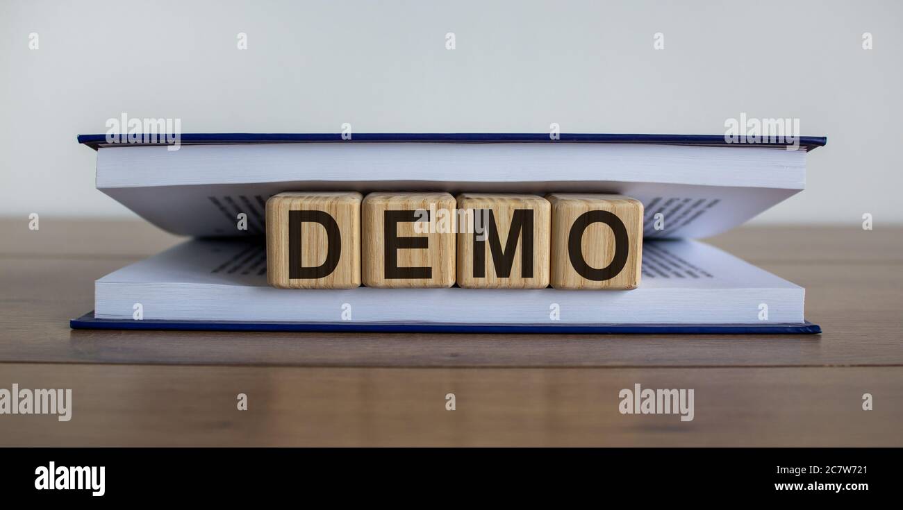 Concept word 'demo' on wooden circles between pages of a book on a ...