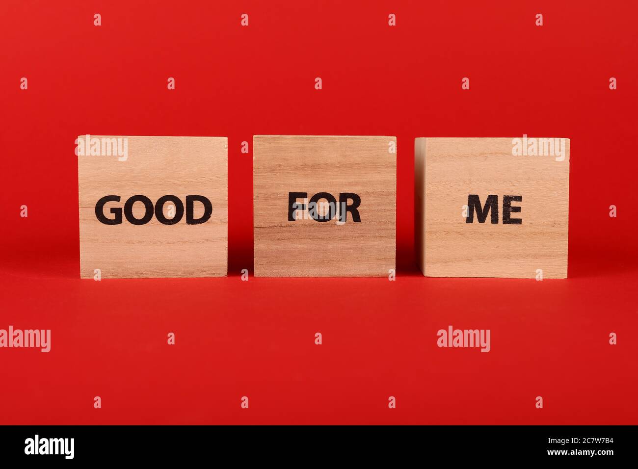 Close up three wooden cube signs with GOOD FOR ME words over red ...