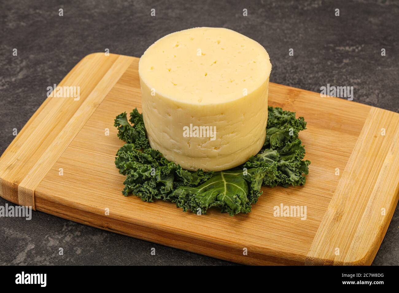 Yellow round dairy soft cheese piece Stock Photo - Alamy