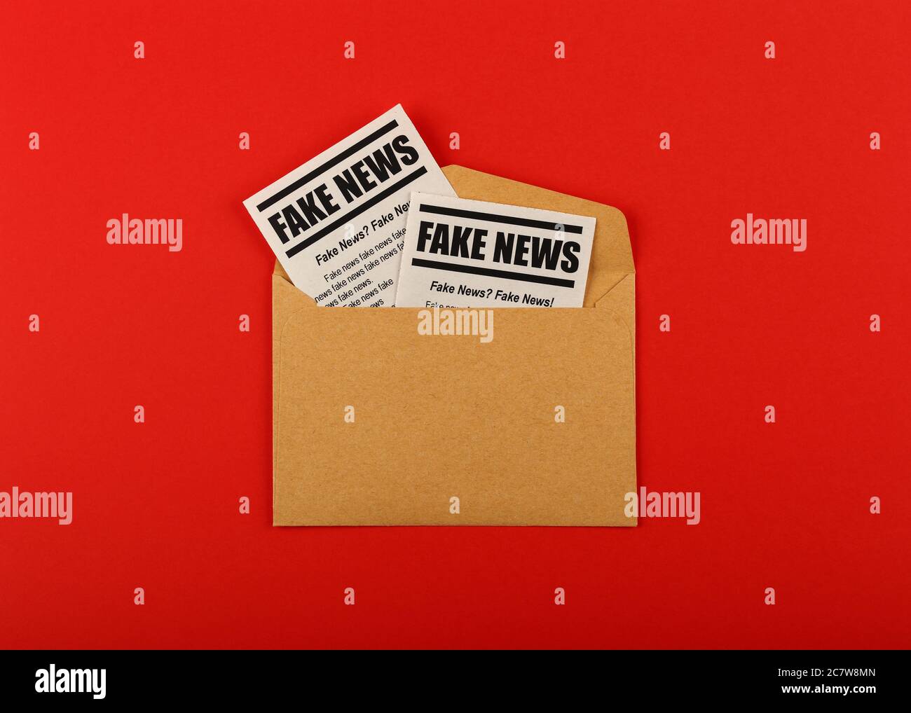Close up brown paper mail envelope with FAKE NEWS newspapers over red ...