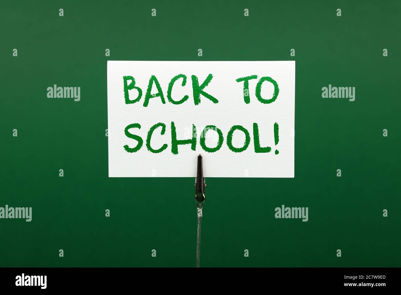 Back to school white crayon handwritten sign over green paper ...