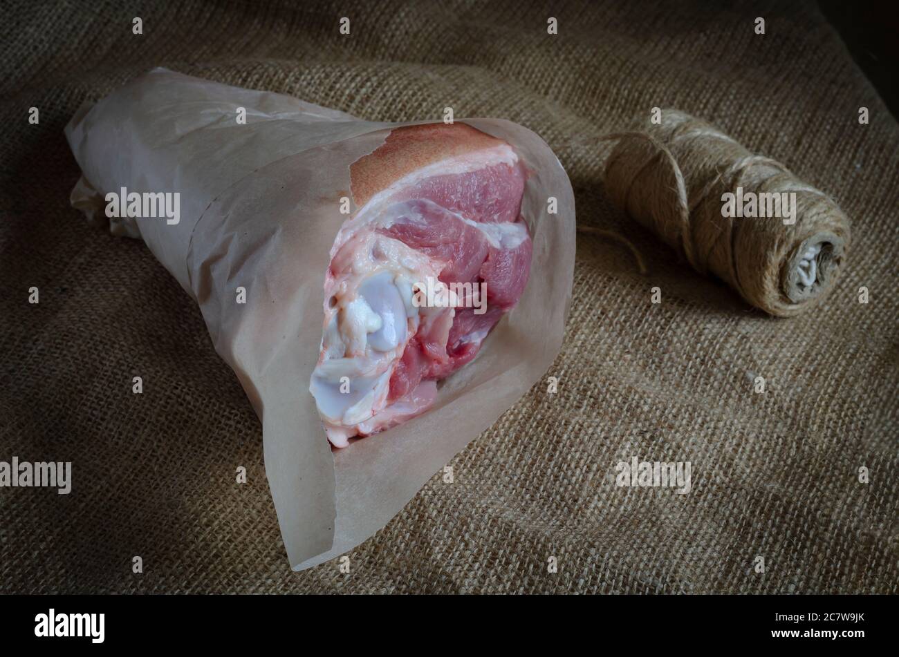 Raw pork knuckle wrapped in burlap wrapping paper. Eco-friendly ...