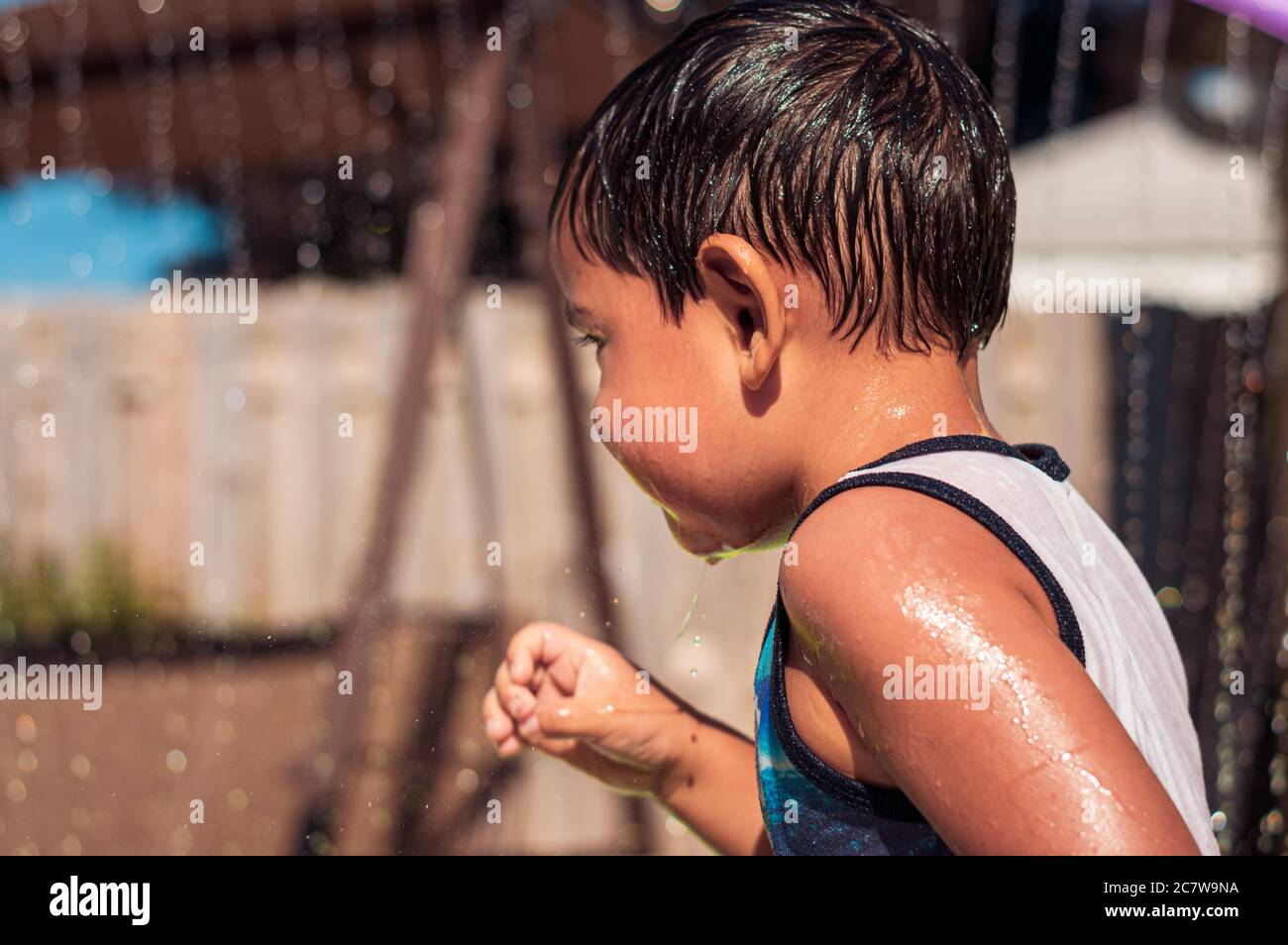 Boy is running at pool party, no face. A backyard pool party at home ...