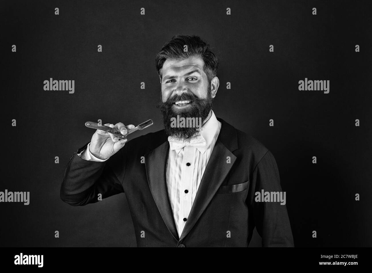 I am barber. Happy barber dark background. Bearded man hold classic ...