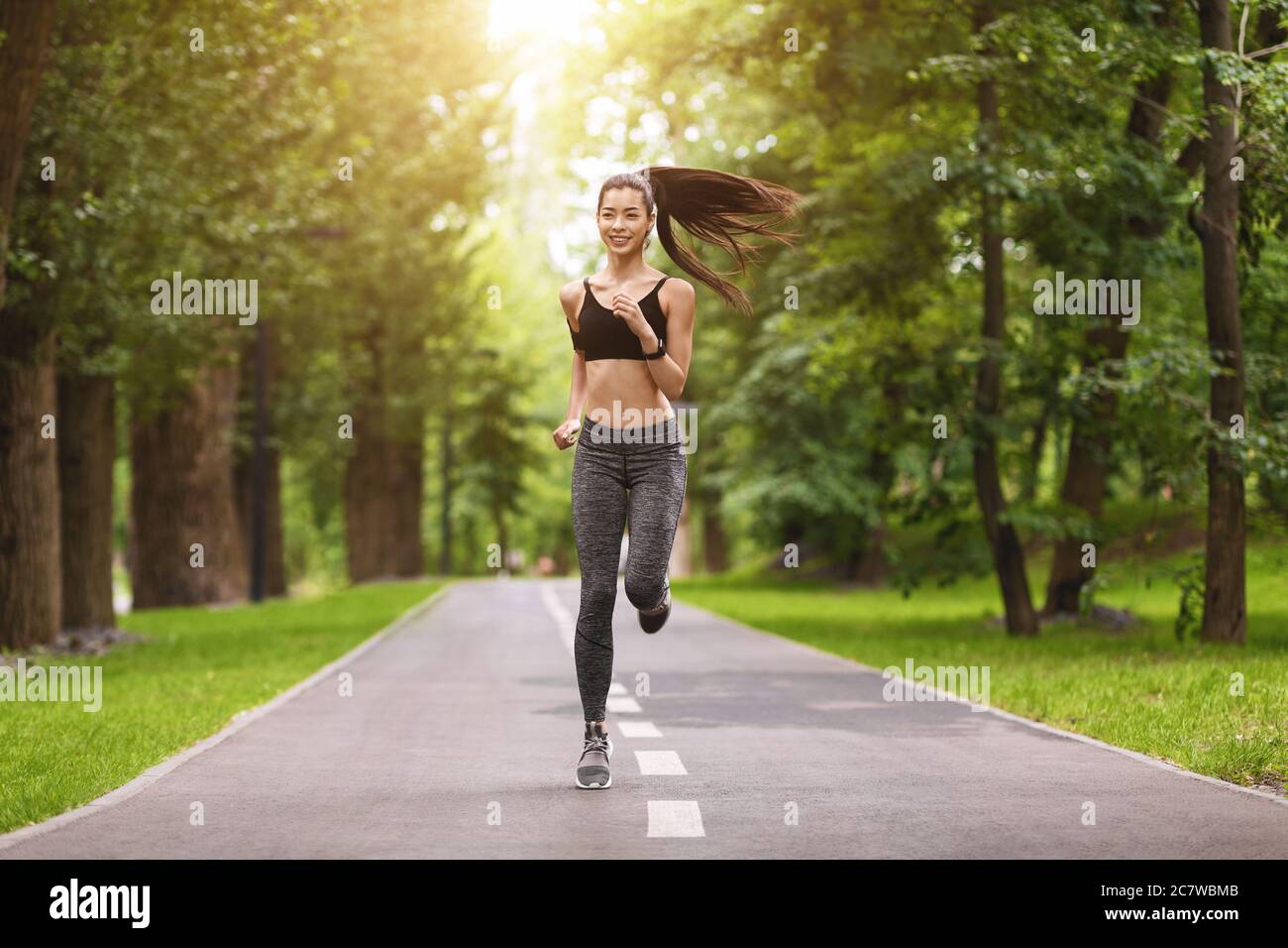 Sporty Morning. Cheerful Asian Girl Running On Path In City Park Stock ...
