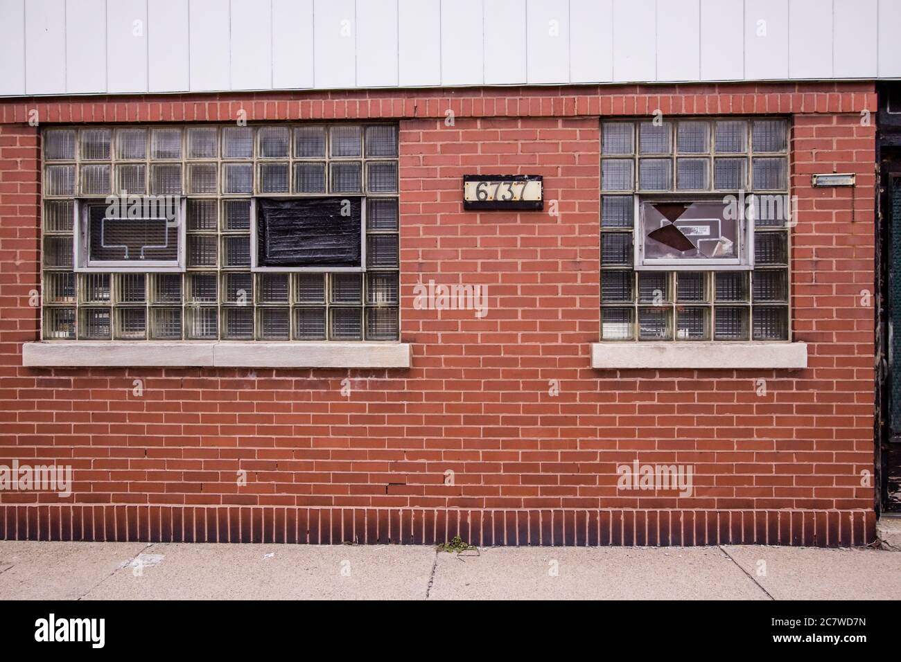 Glass block windows smart in a red brick wall. On an abandoned building ...