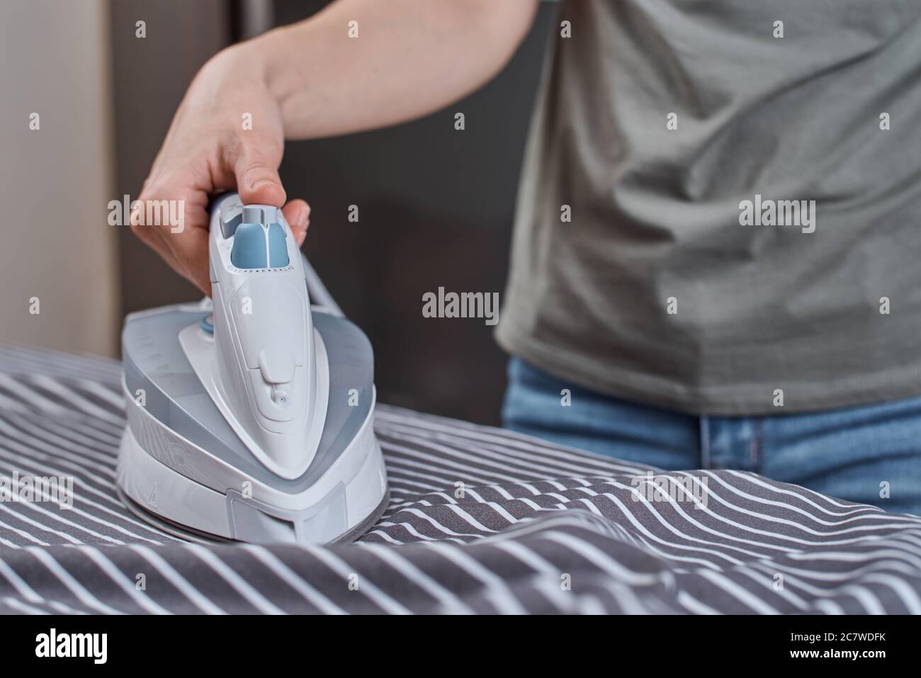 Woman ironing clothes on ironing board with modern iron Stock Photo - Alamy