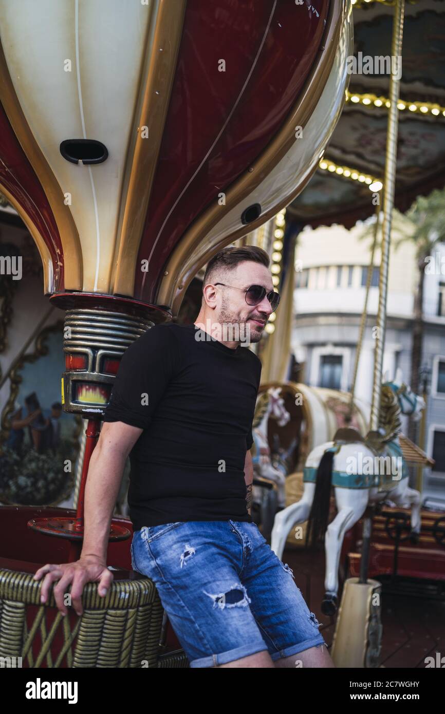 Young Caucasian male spending fun time in an attraction park with a ...
