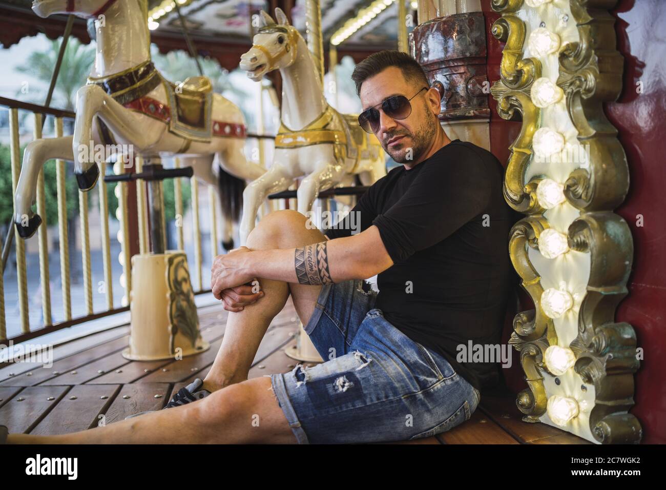 Young Caucasian male spending fun time in an attraction park with a ...