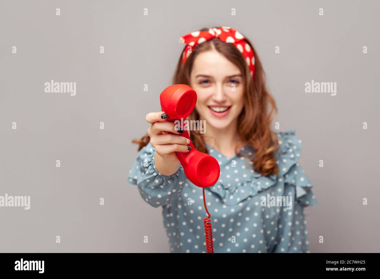 Take it, answer call! Charming happy pinup girl giving phone handset ...