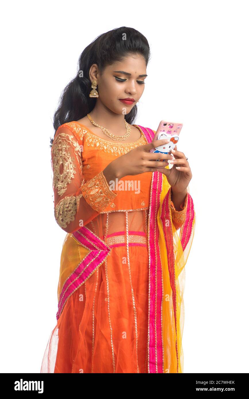 Young Indian traditional girl using a mobile phone or smartphone ...