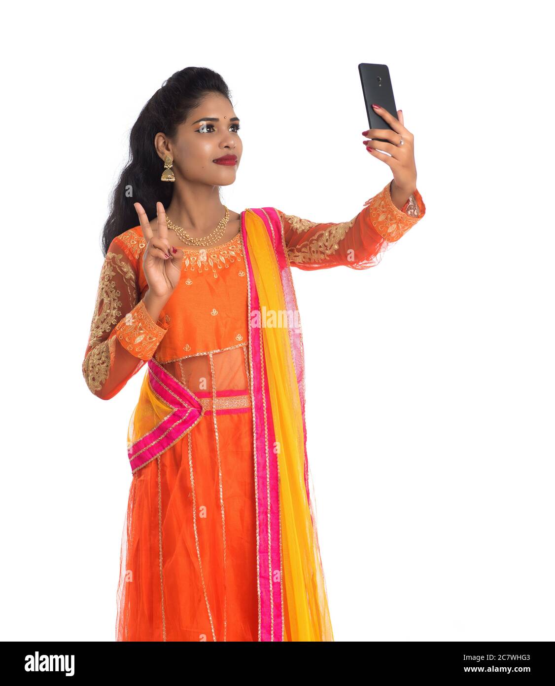Young Indian traditional girl using a mobile phone or smartphone ...