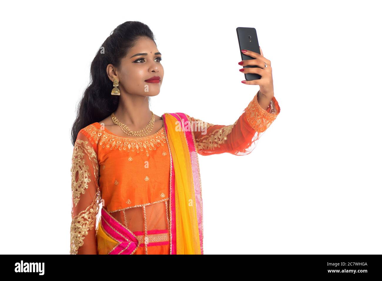 Young Indian traditional girl using a mobile phone or smartphone ...