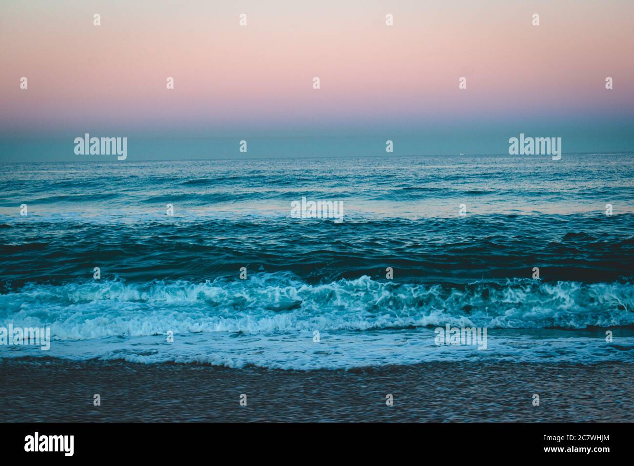 Beautiful shot of waves on the beach during sunset Stock Photo - Alamy