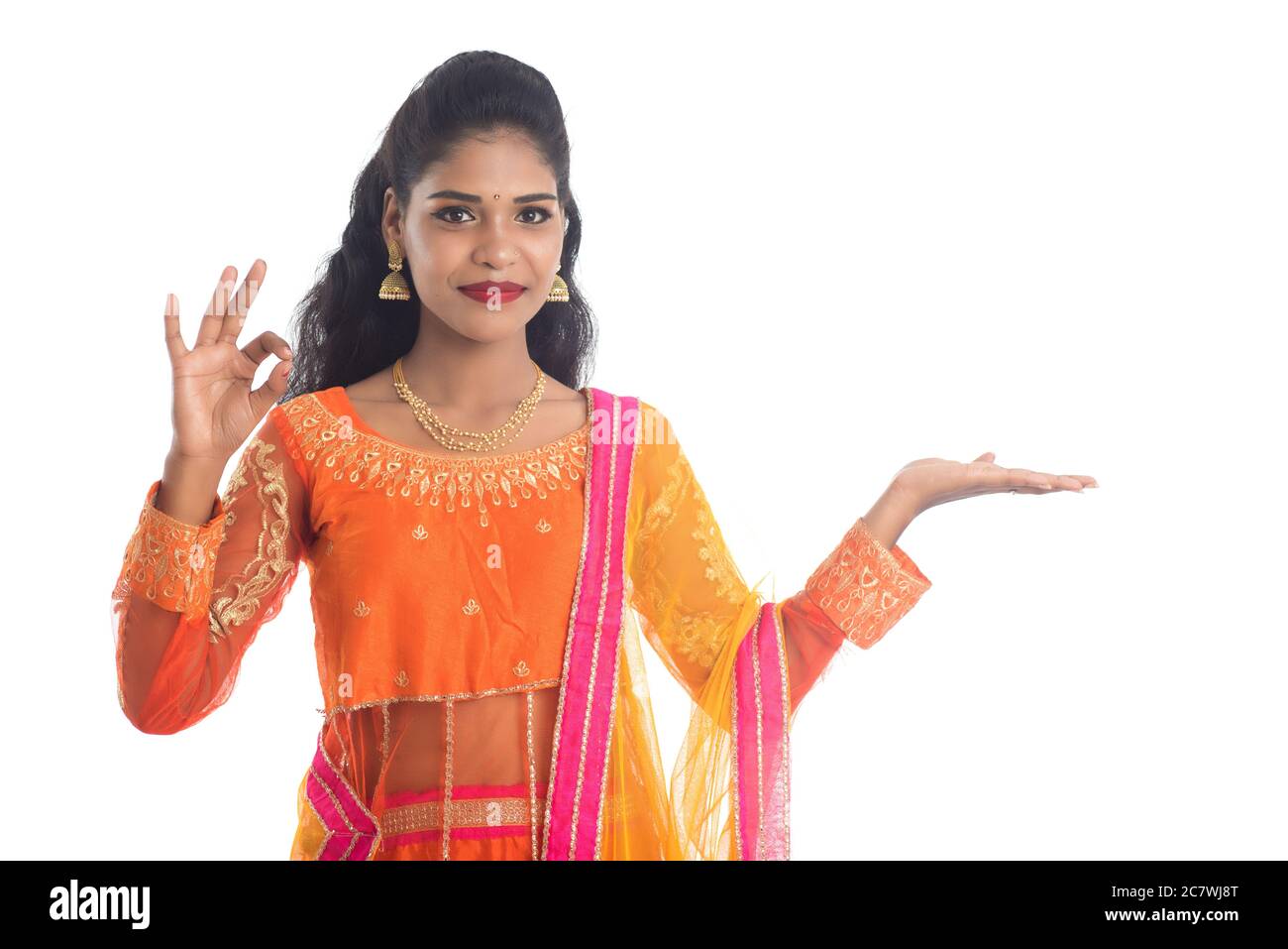 Portrait of cheerful Indian traditional young woman presenting ...