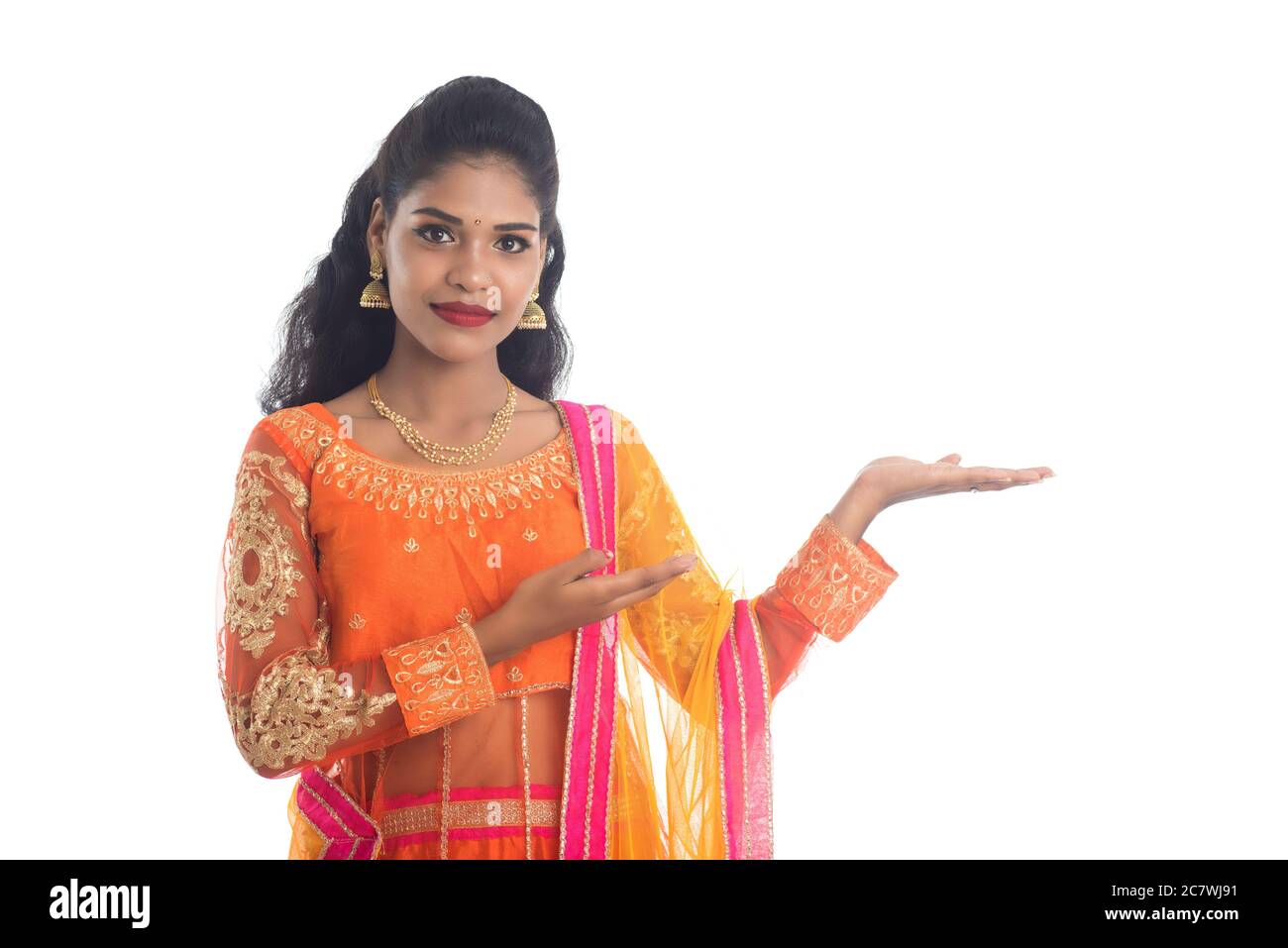 Portrait of cheerful Indian traditional young woman presenting ...