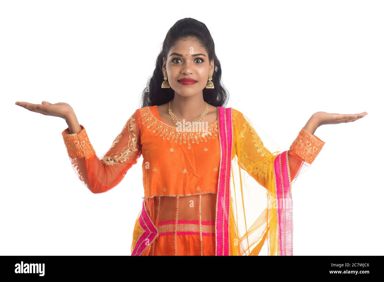 Portrait of cheerful Indian traditional young woman presenting ...