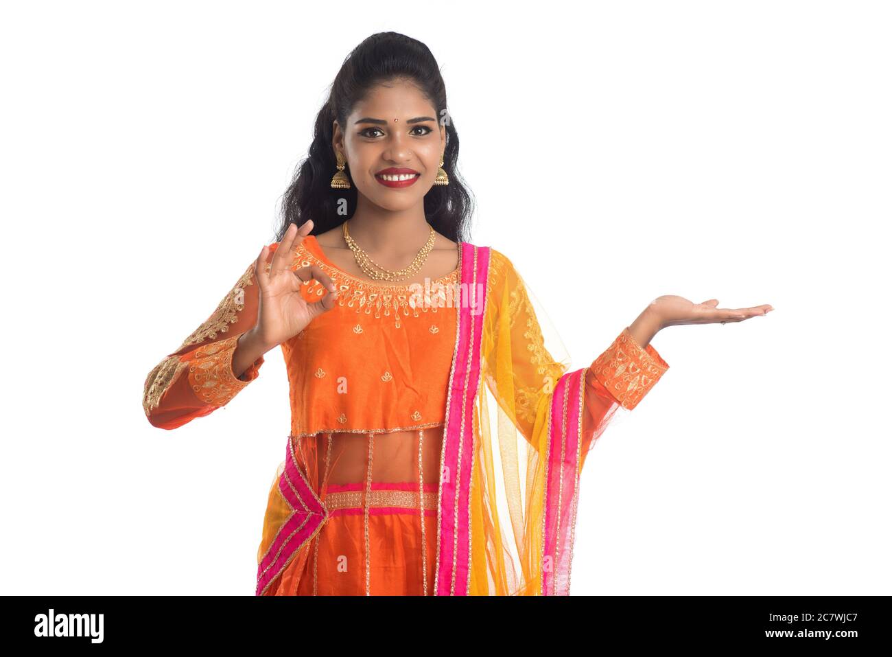 Portrait of cheerful Indian traditional young woman presenting ...
