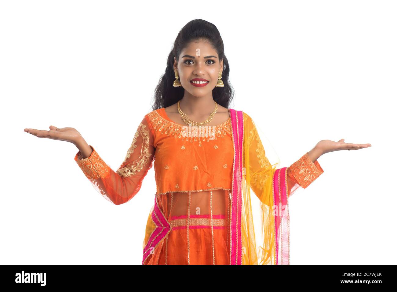Portrait of cheerful Indian traditional young woman presenting ...