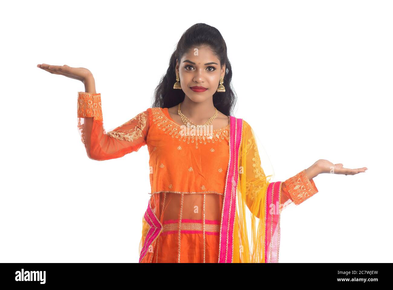 Portrait of cheerful Indian traditional young woman presenting ...