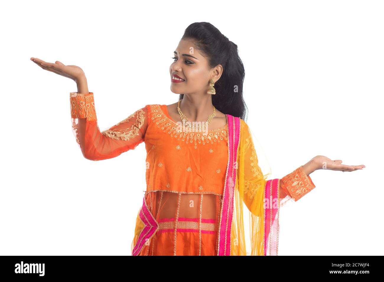 Portrait of cheerful Indian traditional young woman presenting ...