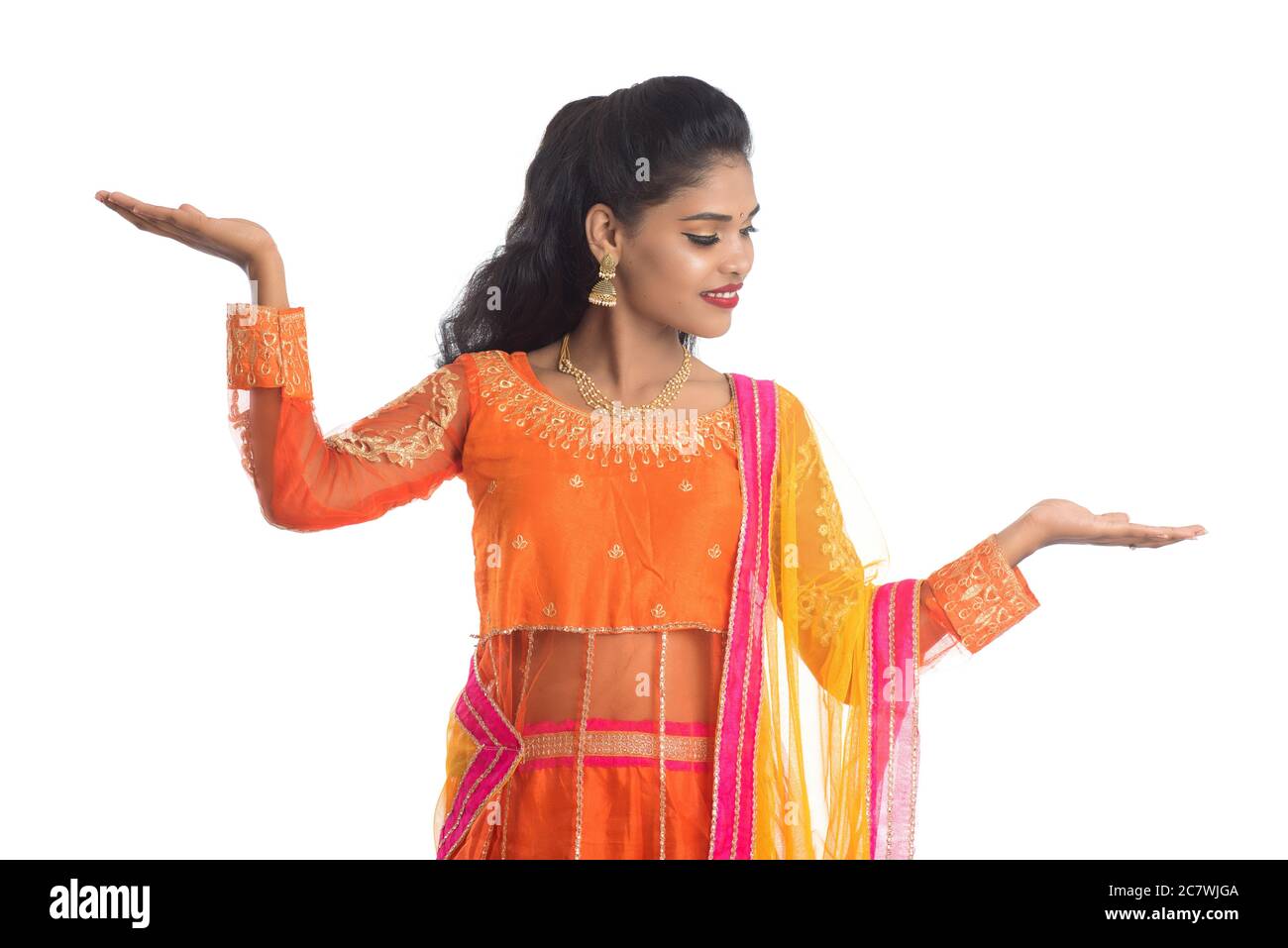 Portrait of cheerful Indian traditional young woman presenting ...