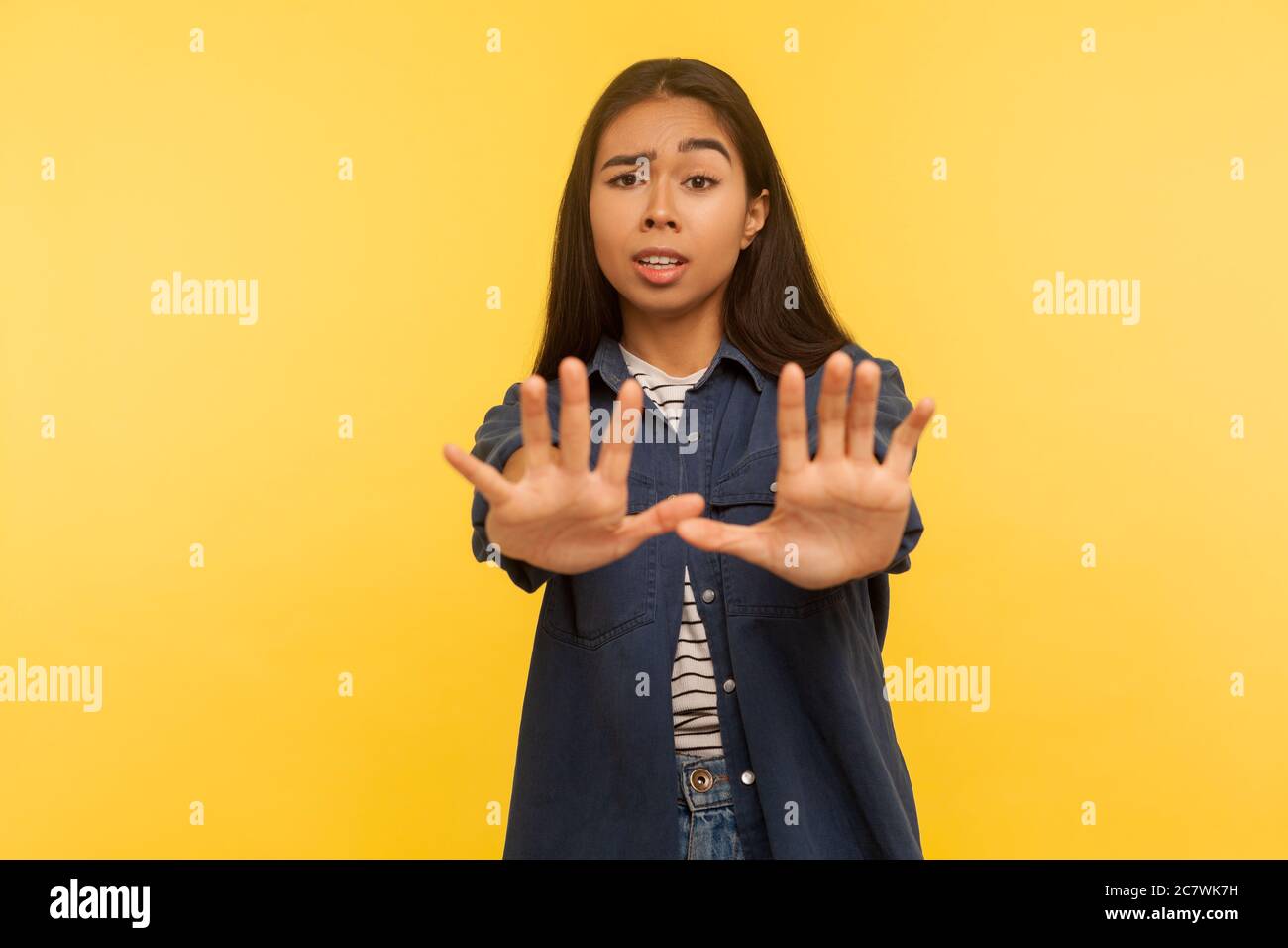 No, I'm afraid! Portrait of scared girl in denim shirt standing with ...