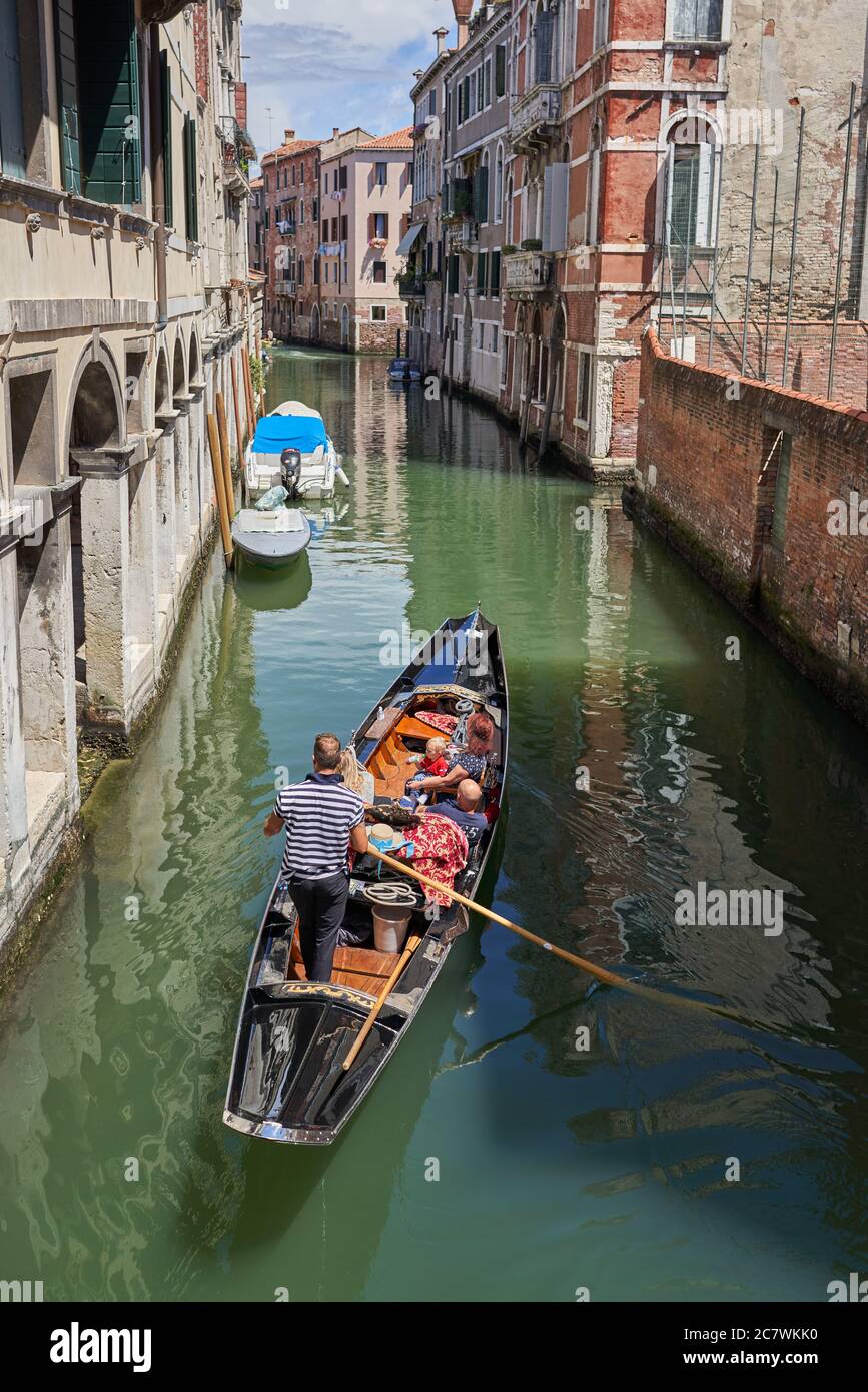 Sandolo boat in a canal in Venice, during a tour on a sunny summer day ...