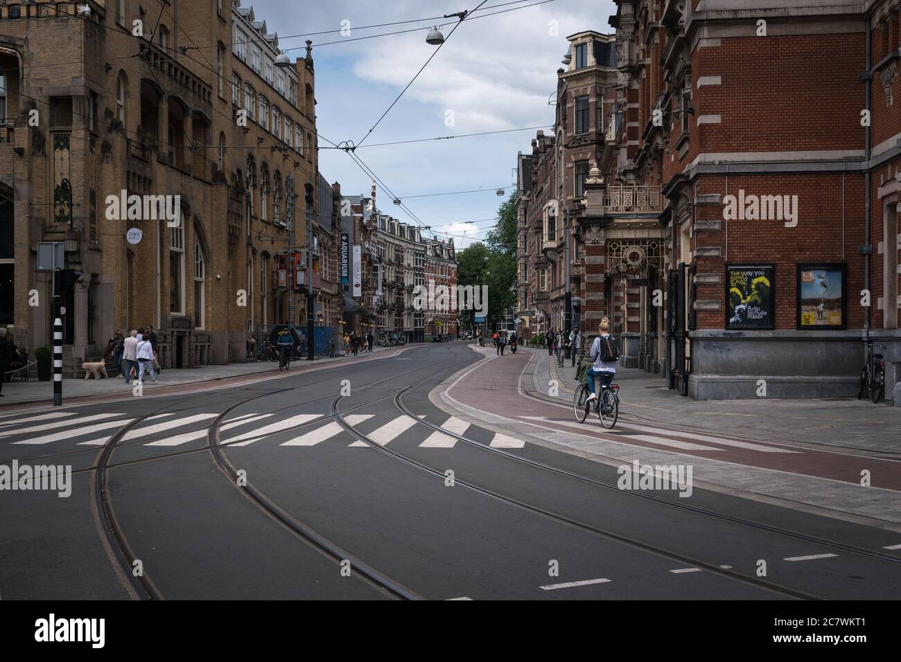 People walking the streets of downtown Amsterdam on a cloudy day ...