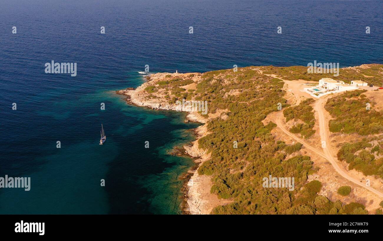 Aerial shot of a mountainous bay shore with blue waters and one boat ...