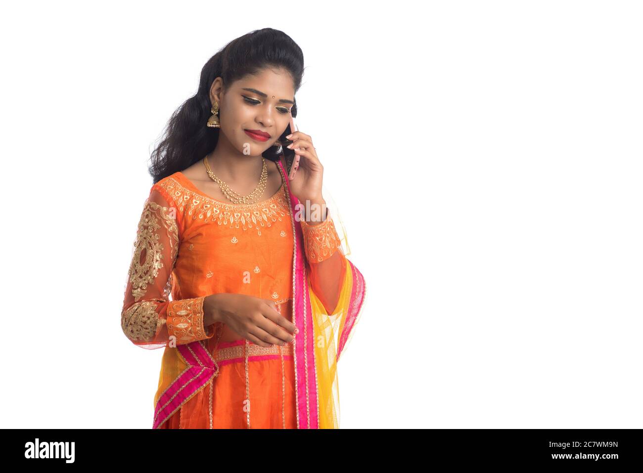 Young Indian traditional girl using a mobile phone or smartphone ...