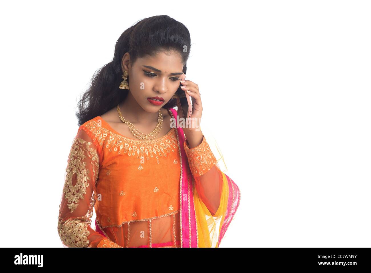 Young Indian traditional girl using a mobile phone or smartphone ...