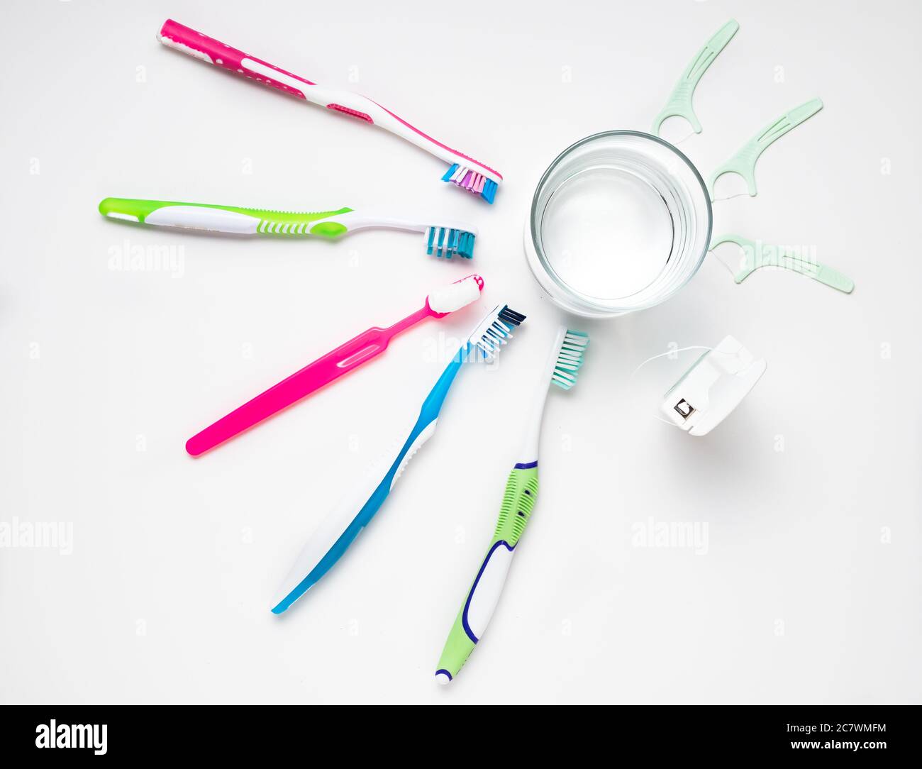 Oral hygiene related objects: tooth brushes, floss and glass of water ...