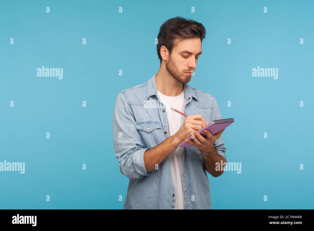 Portrait of man journalist in denim shirt making notes in paper ...