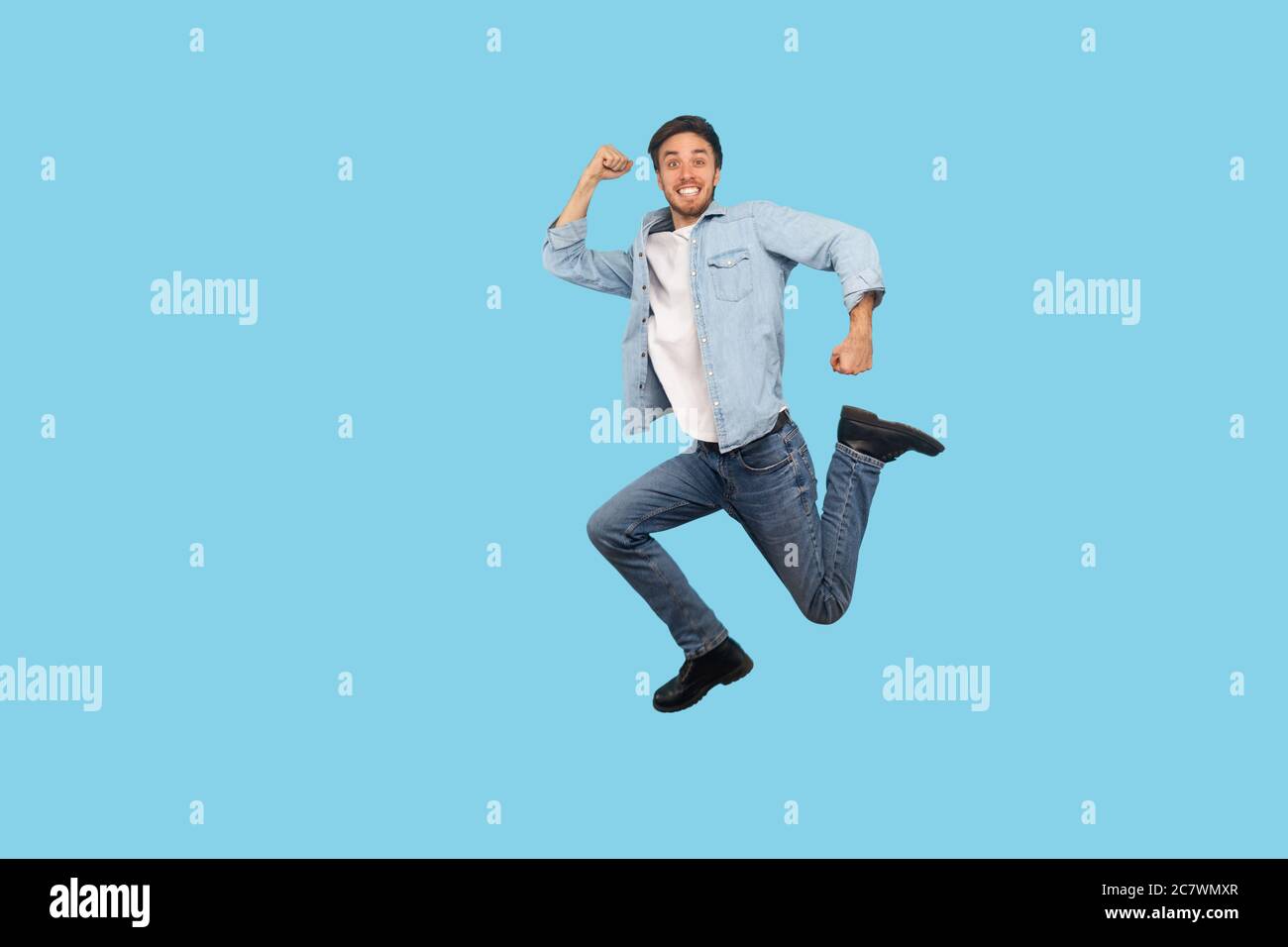 Full length, man in denim outfit flying and jumping in air with ...